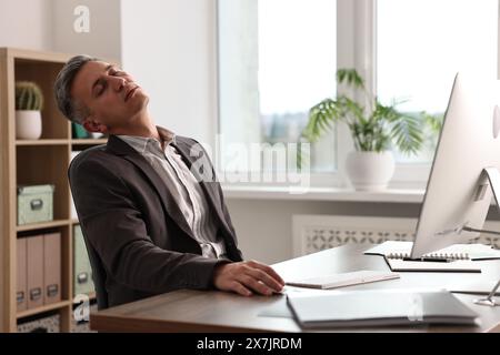 Man snoozing at wooden table in office Stock Photo - Alamy