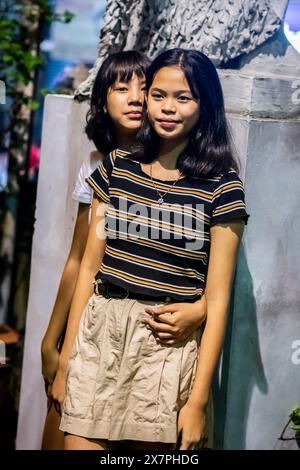 Two young filipino girlfriends hug outside Santo Nino de Tondo Church ...