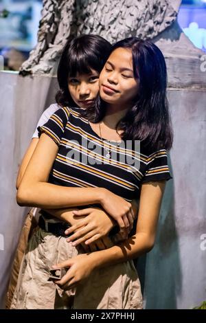 Two young filipino girlfriends hug outside Santo Nino de Tondo Church ...