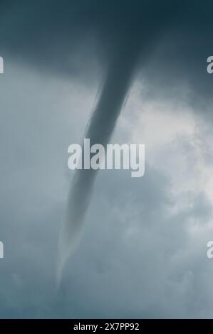 A tornado coming out of a supercell in Europe. A tornado is a violently ...