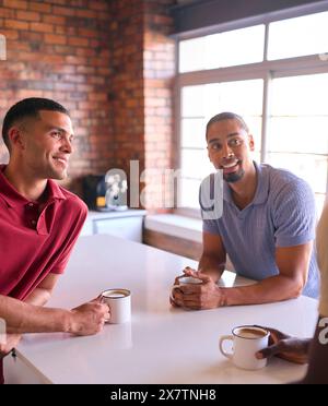 Multi-Cultural Businessmen Taking Coffee Break In Kitchen Area Of ...