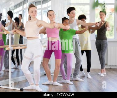 Teenage girl practicing plie position of ballet during choreography ...