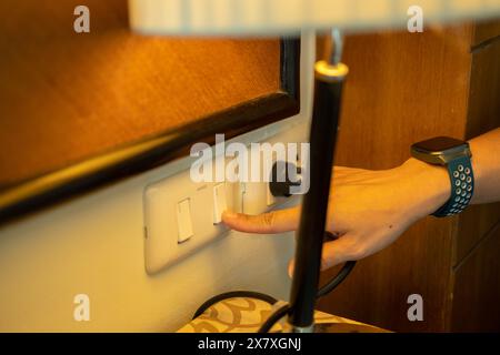 A woman's hand is pulling an electrical plug to turn off a switch. to save energy Stock Photo ...