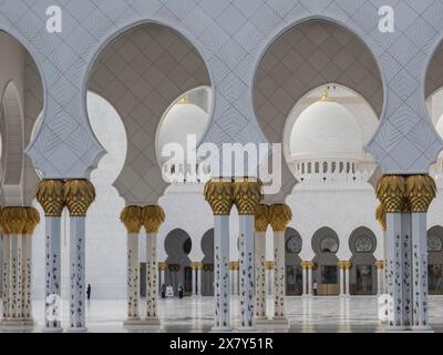 Arcades with golden decorations and white columns, Islamic architecture ...