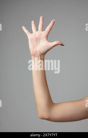 Woman's Arm Extended With Hand Open and Fingers Against a White ...