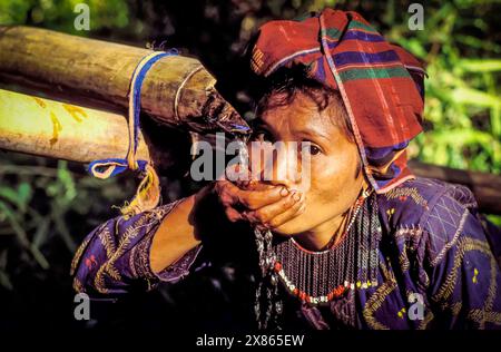 Philippines, Mindanao; Woman of the T'boli tribe drinking water from a ...