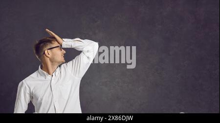 Embarrassed man keeps his hand on his forehead remembering that he ...