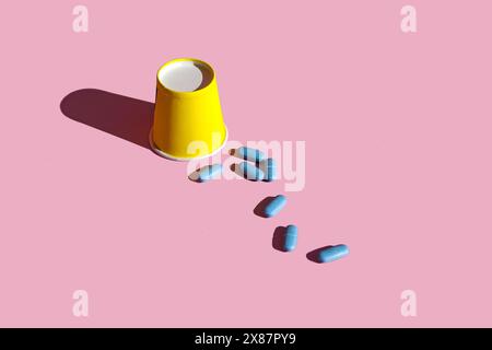 Paper cup with blue pills and blister pack over pink background Stock ...