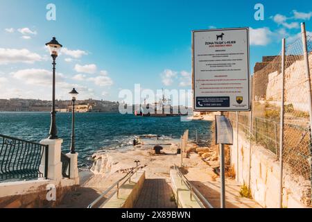 Rinella slipway and dog beach in Kalkara, Malta. A low-lying rock that ...