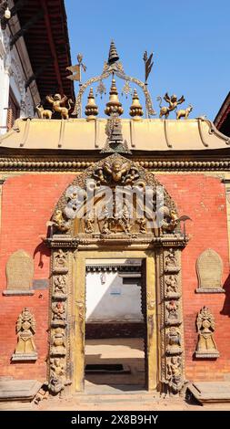 Golden gate of a Nepalese temple with traditional sculptures under a ...