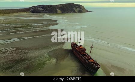 Aerial view of a ship aground and rusty on the coast of Cabo San Pablo ...