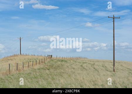 Wire fence and utility poles over open prairie at Pawnee National ...