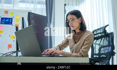 Asian prompt engineer develop coding app with software data sitting in ...