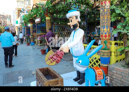 Urumqi, China. 25th May, 2024. A vendor is making naan bread at the ...