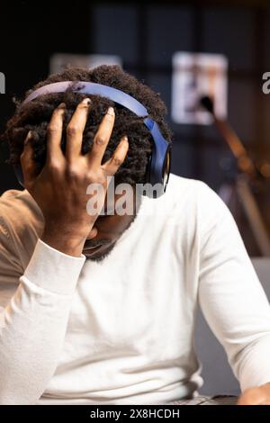 Gamer wearing headphones face palming himself in frustration after ...