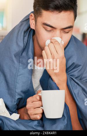 Asian man blowing nose on sofa at home for cold and flu relief Stock ...