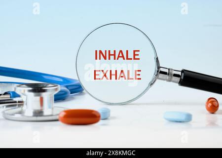 INHALE EXHALE written words through a magnifying glass on a light ...