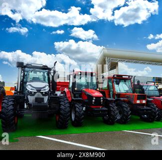 The new red agricultural tractors of various models stand in a row at ...