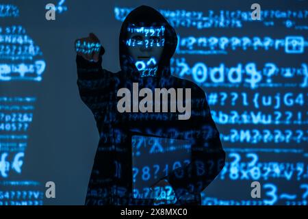Hacker with projection of programming code pointing at something in ...
