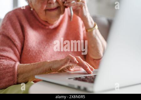 Online scams targeting seniors. Scammer sending email to elderly woman ...