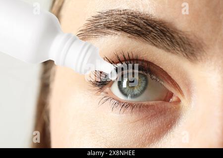 Woman applying eye drops on light background, closeup Stock Photo - Alamy