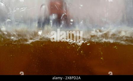 Mechanism spraying liquid substance inside glass container. Media ...