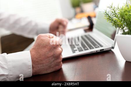 Angry businessman hitting his desk with his clenched fists; panoramic ...