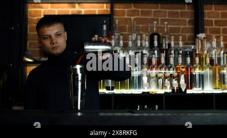 The barman preparing perfect cocktail, standing behind the bar counter ...
