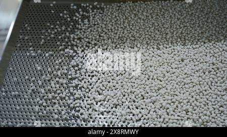Cleaning of polymer granules. Creative. Mesh for cleaning white polymer ...