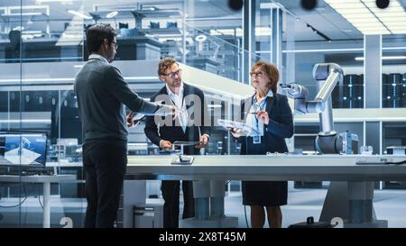 Engineers programming a robotic arm for industrial automation. Focus on ...