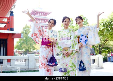 Japanese friends wearing yukata visiting traditional temple in Tokyo ...