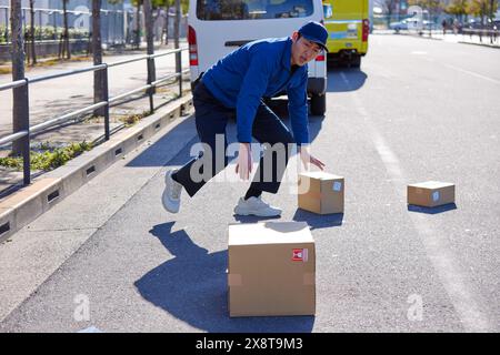 Japanese delivery man dropping boxes Stock Photo - Alamy
