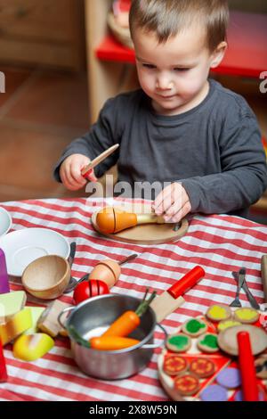 Toddler playing as a cook with wooden toys. Symbolic play, learning ...
