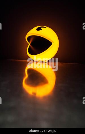 Illuminated yellow smiley face lamp casting a cheerful glow and shadow ...