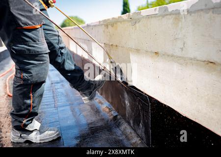 Worker is unroll rolled up, sheet of waterproofing installation ...