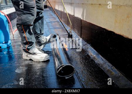 Worker is unroll rolled up, sheet of waterproofing installation ...