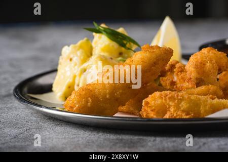 Deep fried shrimp tempura with potato salad on a metal plate Stock ...
