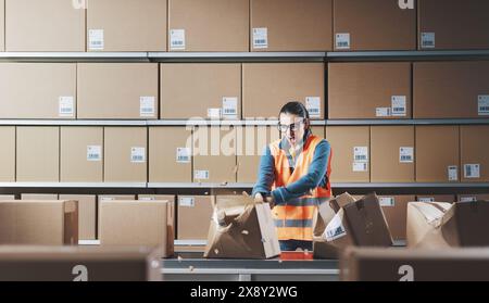 Angry aggressive warehouse worker hitting cardboard boxes with a bat ...
