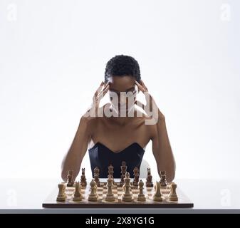African american woman playing chess game sitting on table at home ...