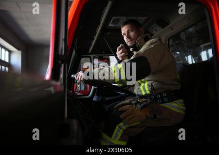 Firefighter using portable radio set while driving fire truck Stock ...