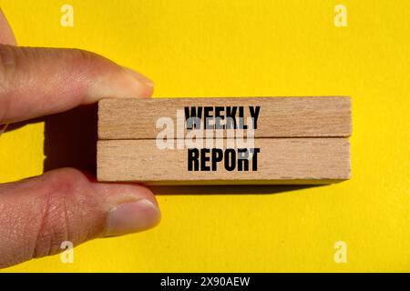 Weekly report words written on wooden blocks with yellow background ...