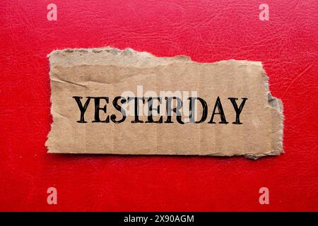 Yesterday word written on ripped white paper piece with brown ...
