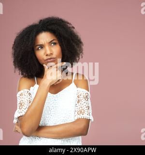 Black confused girl in pink hoodie. Young attractive woman is shrugging ...