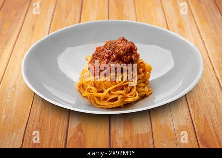 Tajarin pasta noodles with tomato sauce and meat in white plate ...