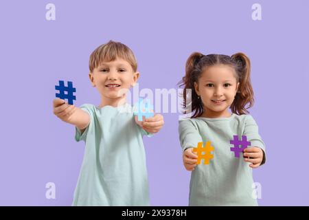 Cute little kids with hashtags on lilac background Stock Photo - Alamy