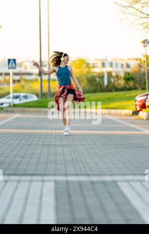 Young woman with curly hair expressing happiness against a blue ...