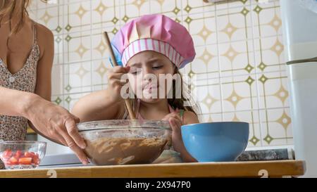 a girl dressed as a cook enjoying an afternoon of cooking with her ...