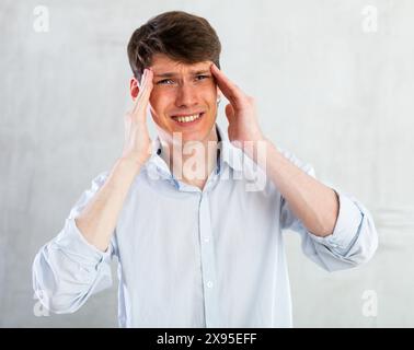 Young man experiencing acute headache in living room Stock Photo - Alamy