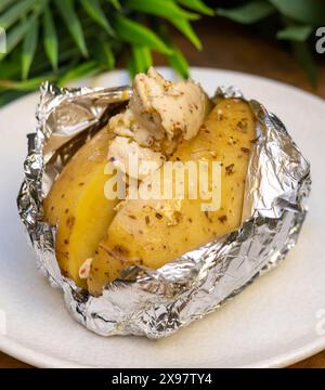 Potato roasted over fire with butter Stock Photo - Alamy