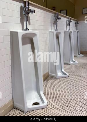 Men's room with white porcelain urinals in line. Modern clean public ...